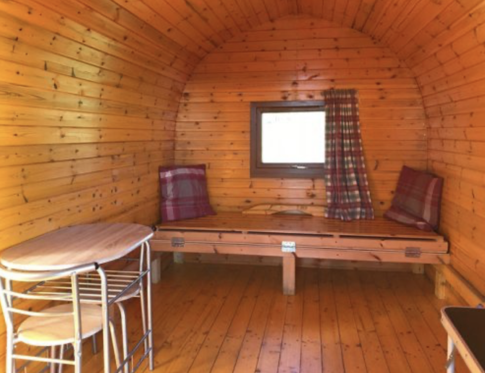Cozy pod interior with sleeping area, table, and amenities